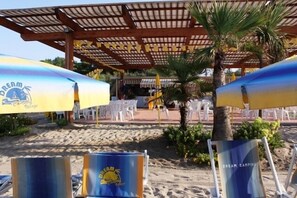 Praia particular, espreguiçadeiras, guarda-sóis 