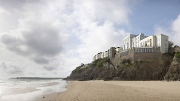Hotel à beira-mar com vista para a praia, localizado em um penhasco com vista para o mar.