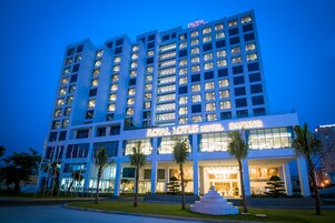 Um hotel com vários andares e uma placa chamativa com a inscrição "ROYAL LOTUS HOTEL DANANG".
