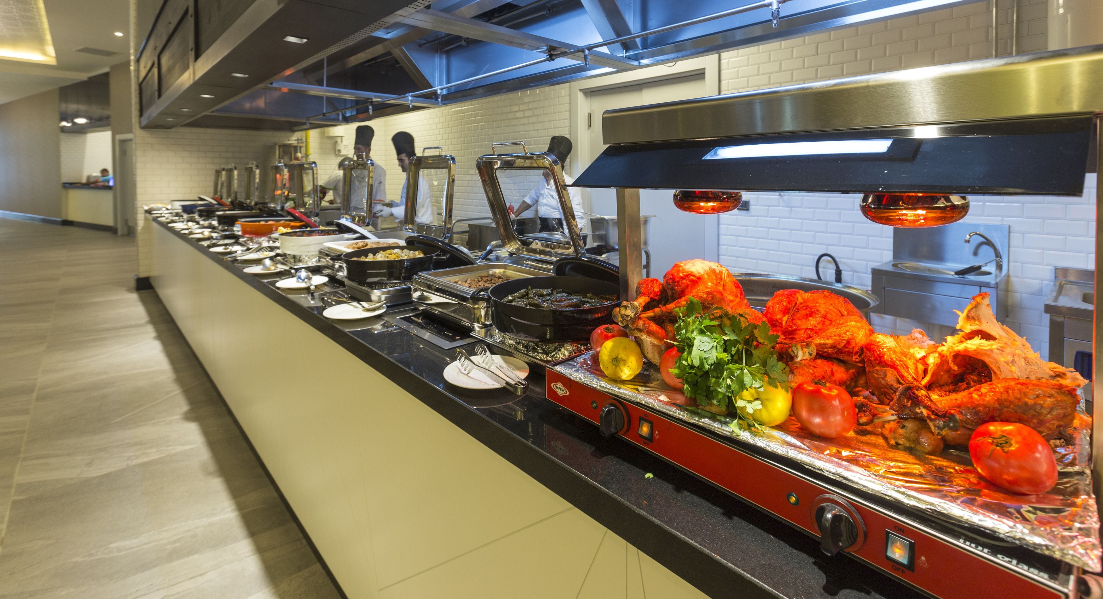 Uma mesa de buffet com diversos alimentos e utensílios.