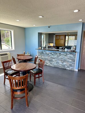 Uma sala de jantar com bancada de pedra e cadeiras de madeira.