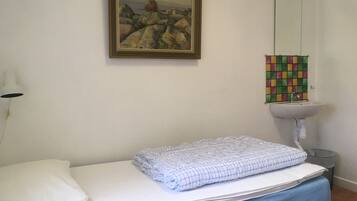 Quarto com cama, pintura, pia e espelho.