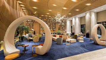 Uma biblioteca moderna com áreas de estar curvas, estantes e um design de teto singular.