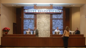 Balcão de recepção de hotel com uma placa em cima.