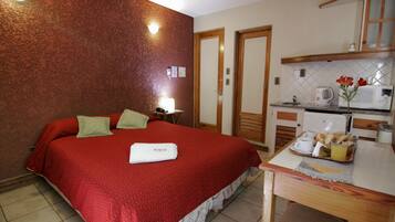 Quarto de hotel com uma cama grande, uma mesa pequena com itens de café da manhã, micro-ondas e cafeteira.