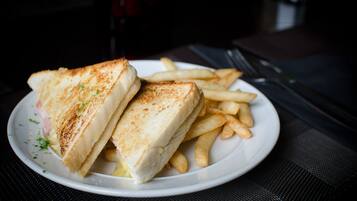 Um prato com sanduíche grelhado e batatas fritas.