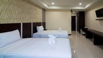 Quarto de hotel com duas camas, televisão de tela plana e um banco.