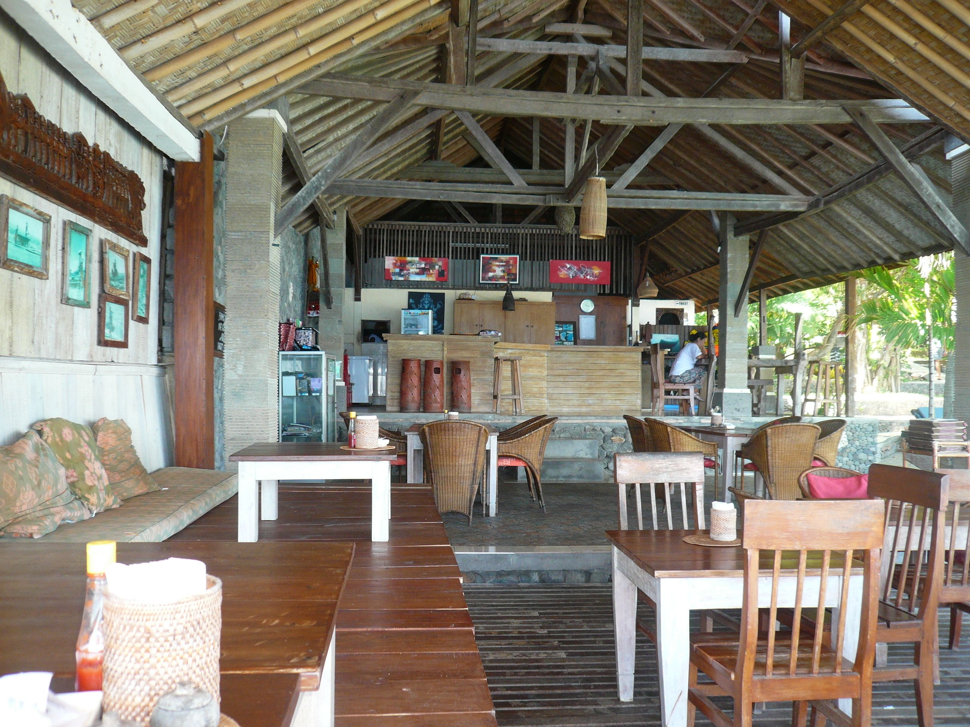 Um restaurante rústico com mobiliário de madeira, um espaço de bar e vista para o exterior.