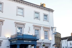 Um edifício histórico com uma placa que diz "WHITE HART PUB & HOTEL".