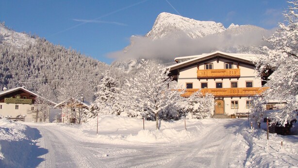 Uma montanha coberta de neve com um edifício em primeiro plano.