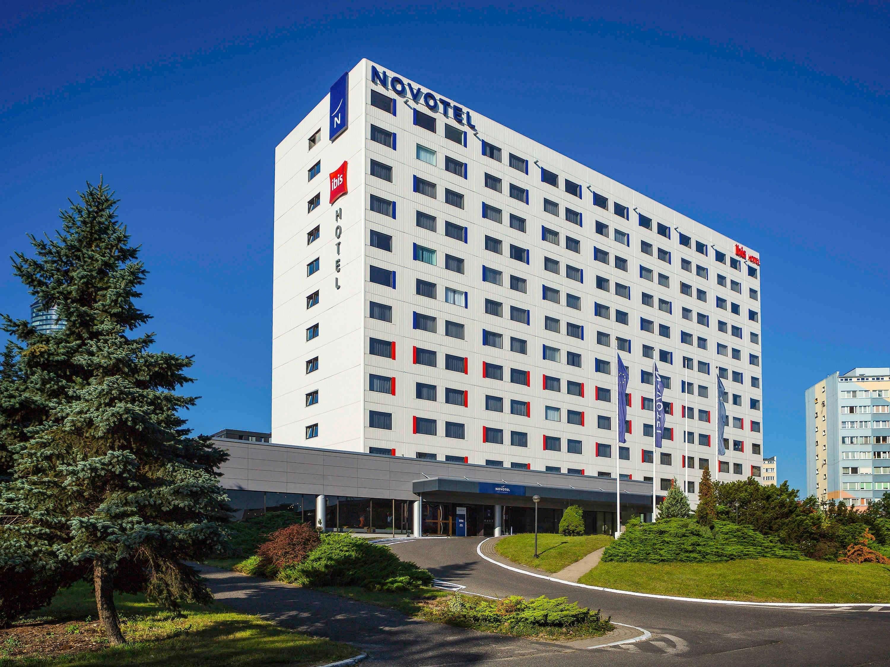 Um hotel Novotel com design moderno, vários andares e entrada coberta.