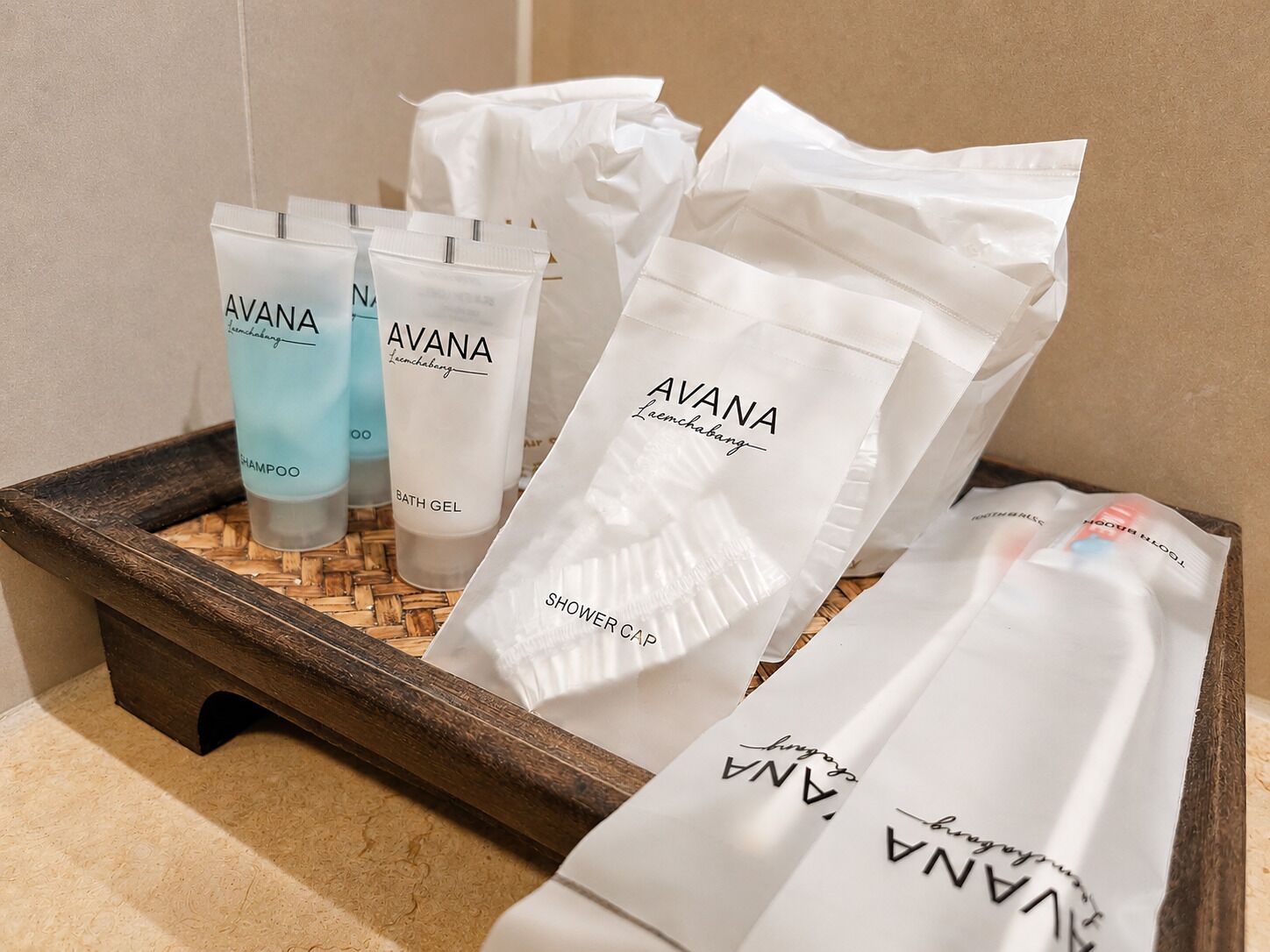 Bandeja com produtos AVANA, incluindo shampoo, gel de banho e touca de banho.
