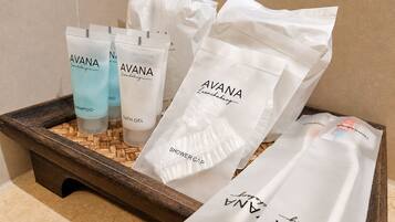 Bandeja com produtos AVANA, incluindo shampoo, gel de banho e touca de banho.