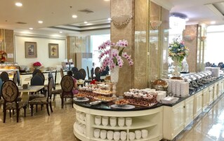 Disposição de buffet com diversos alimentos e um vaso decorativo de flores.