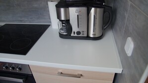 Cozinha com cafeteira, fogão e gaveta.