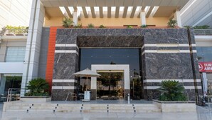Entrada de um edifício moderno, com porta de vidro, degraus e uma placa da Turkish Airlines.