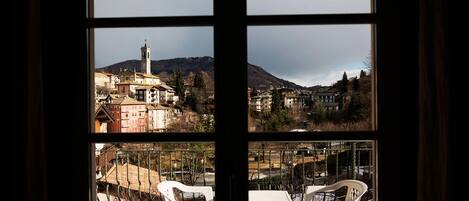 Uma janela com quatro painéis, cada um mostrando uma vista diferente de uma cidade com edifícios, uma igreja e uma montanha.