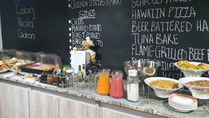 Um buffet de café da manhã com diversos alimentos e acompanhamentos.
