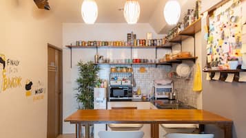 Um frigorífico/congelador grande, um micro-ondas, utensílios de cozinha