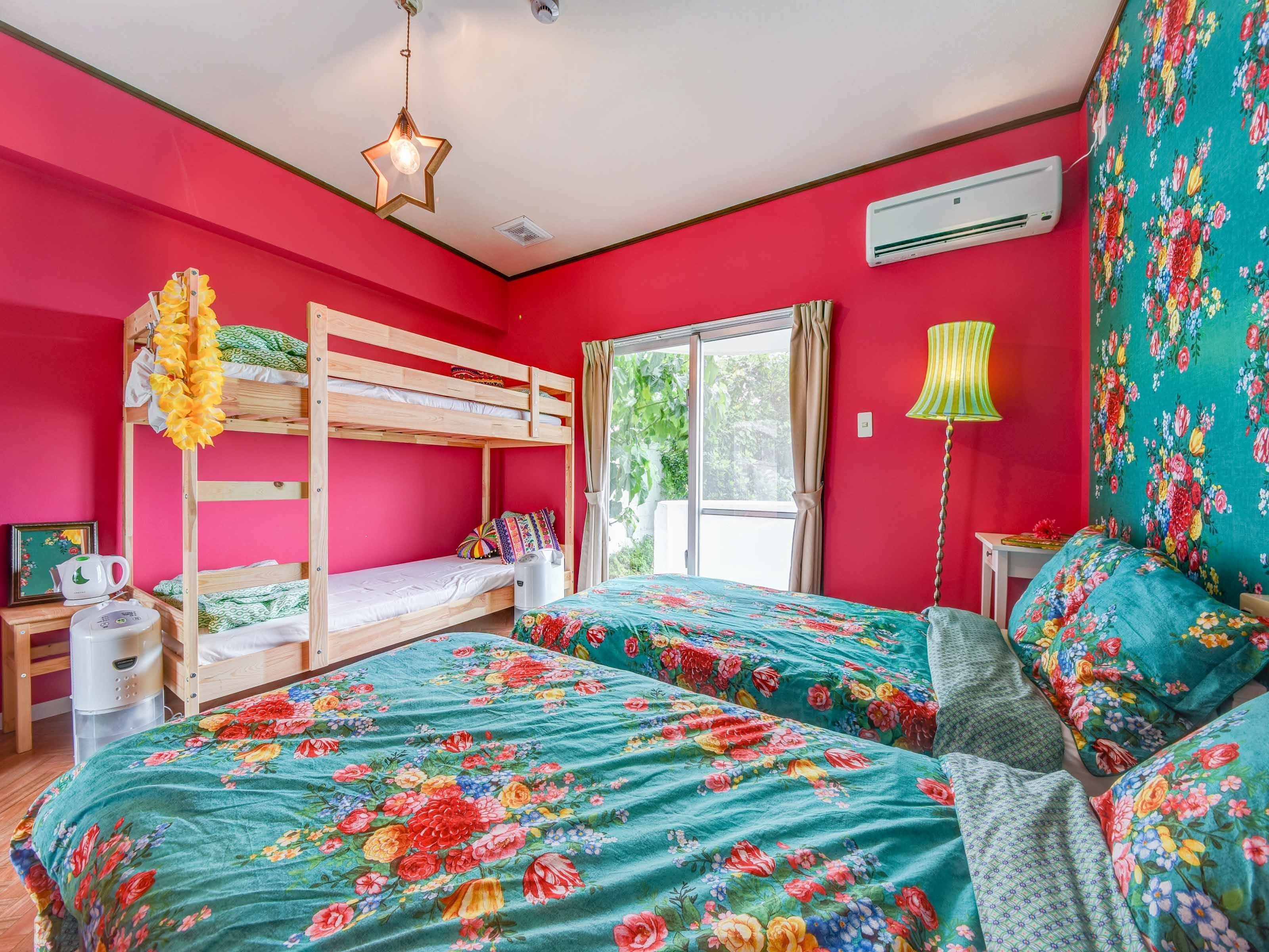 Quarto com duas camas, incluindo uma cama beliche, janela com cortinas, luminária de chão e ar-condicionado.