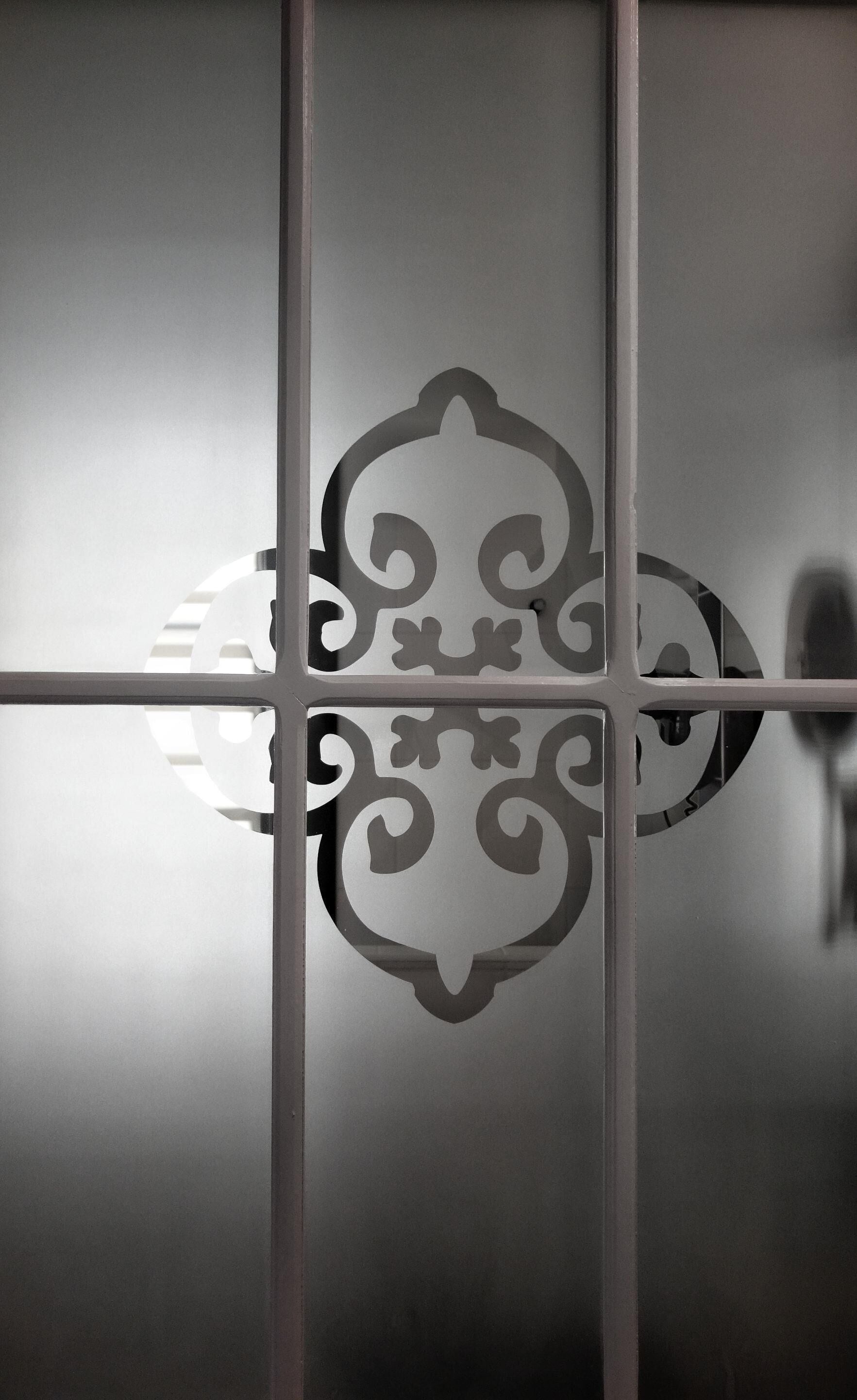 Uma grade de metal decorativa com um desenho ornamentado.