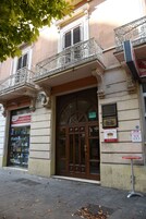 Um edifício com varandas ornamentadas, uma loja com produtos italianos e uma porta com painéis de vidro.