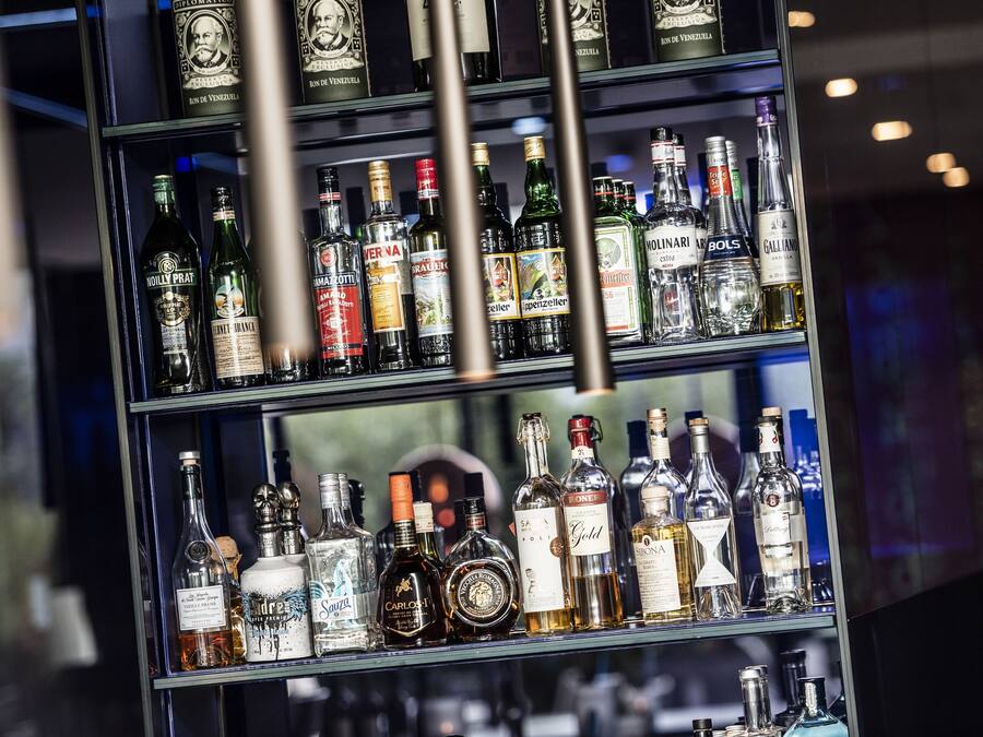 Um bar com prateleiras cheias de garrafas de bebidas.