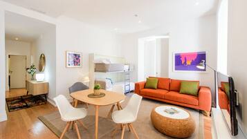 Uma sala de estar moderna com área de jantar, sofá e mesa de centro.