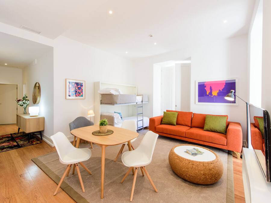 Uma sala de estar moderna com área de jantar, sofá e mesa de centro.