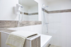 Um secador de cabelo, toalhas fornecidas, sabão, champô 