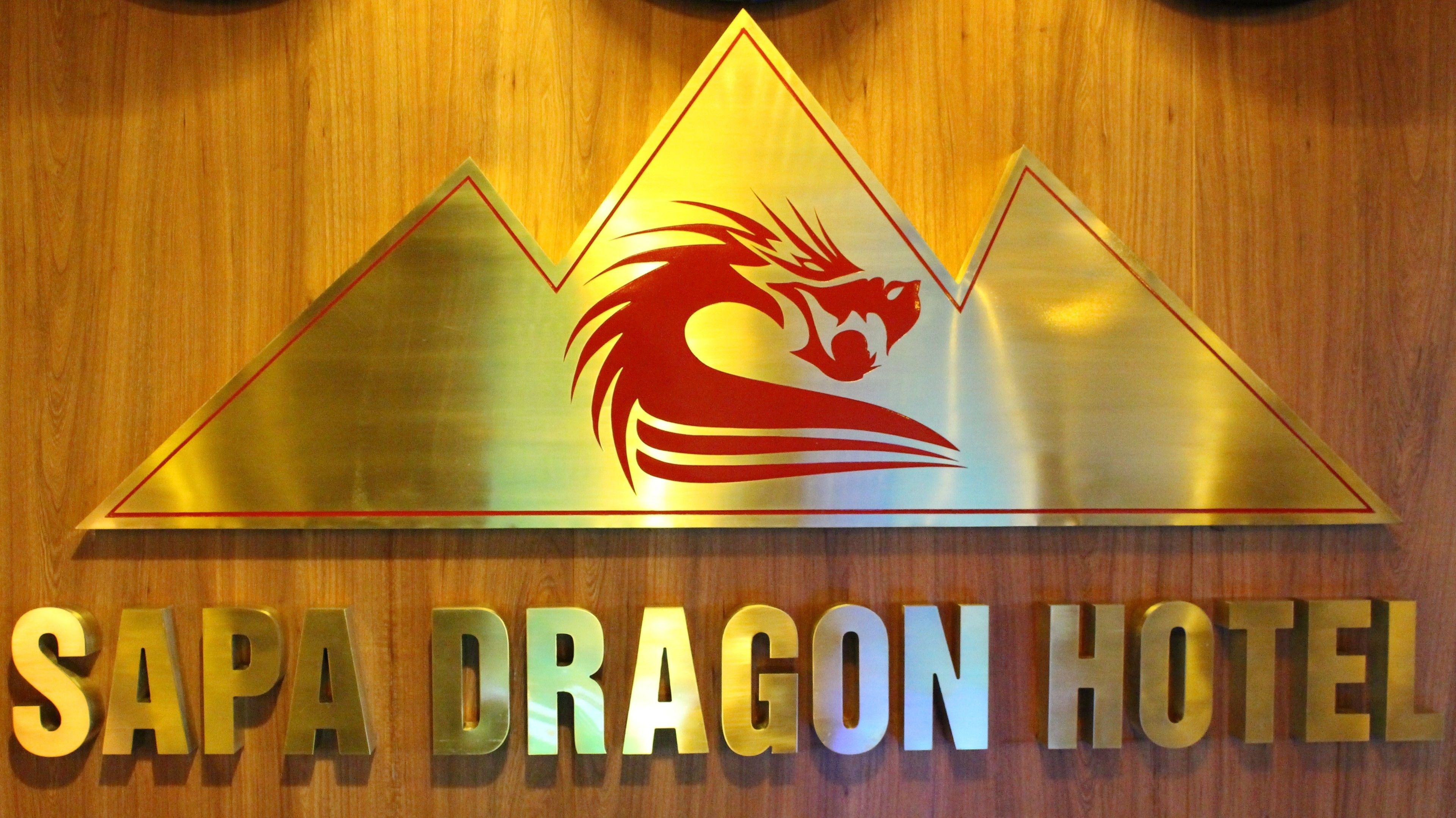 Placa do Sapa Dragon Hotel, com o logotipo de um dragão e o nome do hotel em letras grandes.