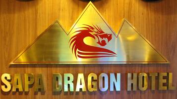 Placa do Sapa Dragon Hotel, com o logotipo de um dragão e o nome do hotel em letras grandes.