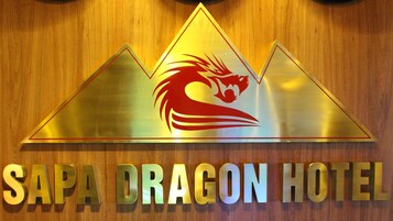 Placa do Sapa Dragon Hotel, com o logotipo de um dragão e o nome do hotel em letras grandes.