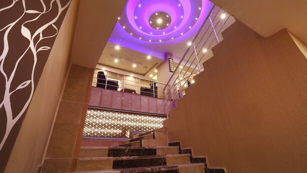 Escadaria moderna com teto decorativo e parede estampada.