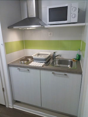 Um frigorífico, um micro-ondas, uma placa de cozinha 