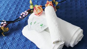 Um edredom azul acolchoado com duas toalhas brancas e um cartão com a inscrição "BioEnergy bath & shampoo".