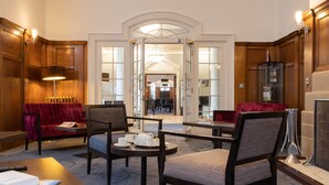 Um saguão de hotel com balcão de recepção, área de estar e vista para a sala de jantar.