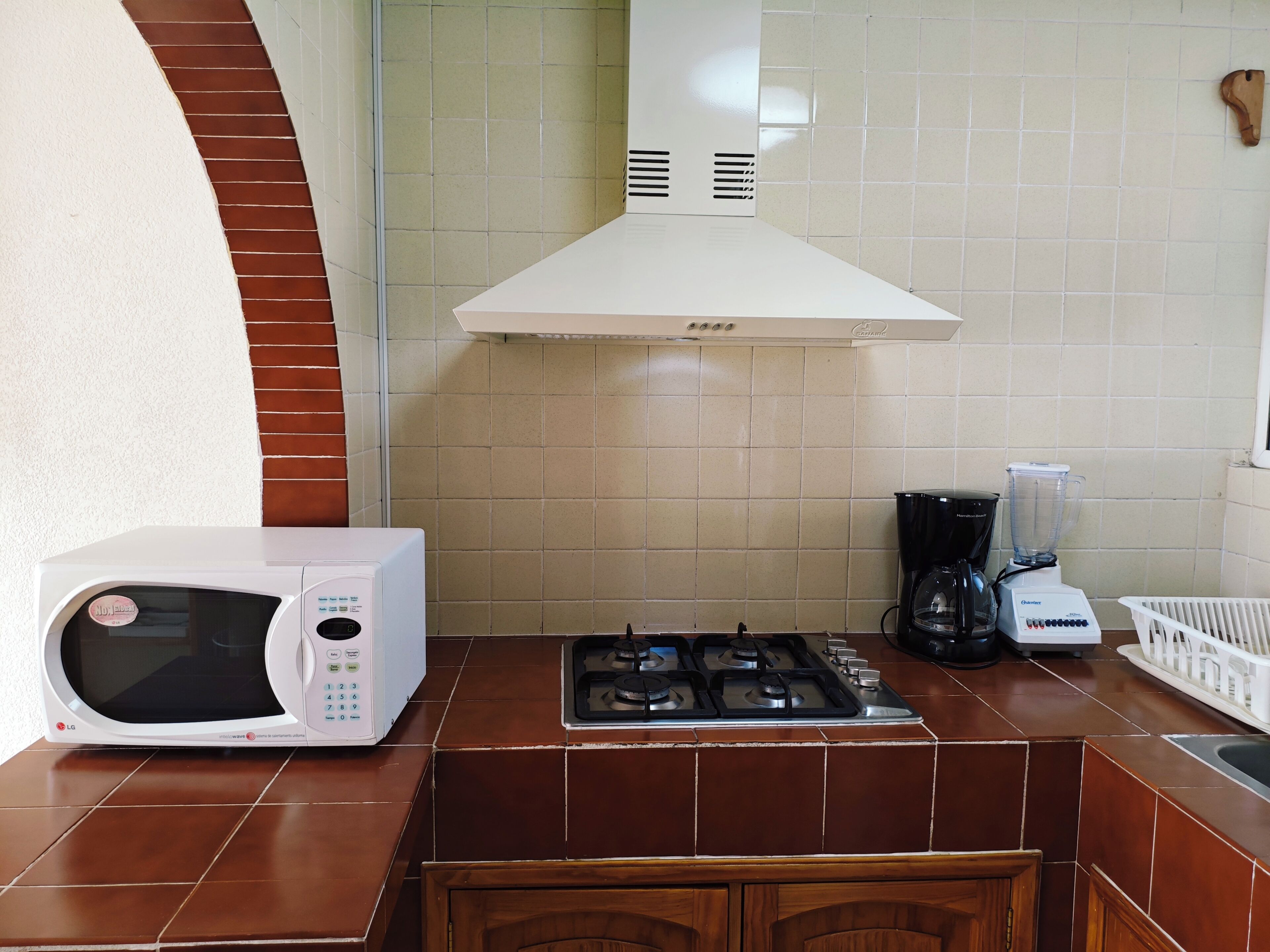 Cozinha equipada com micro-ondas, fogão e máquina de café.