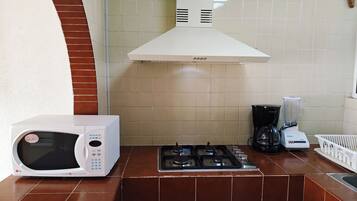 Cozinha equipada com micro-ondas, fogão e máquina de café.