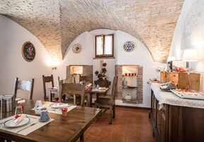 Uma sala de jantar com teto de tijolos, mesas e cadeiras de madeira e um ambiente rústico.