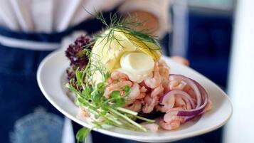 Um prato de salada de camarão com endro, cebola roxa e ovo cozido.