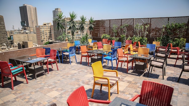 Um terraço no telhado com mobiliário de exterior e vista para a cidade.