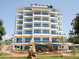 Um hotel com vários andares, um pátio central, área de estar externa e uma escultura de pedra.