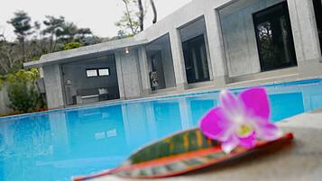 Um edifício moderno com piscina, uma flor e um prancha de remo.