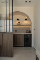 Cozinha moderna com armários de madeira, geladeira preta e forno embutido.