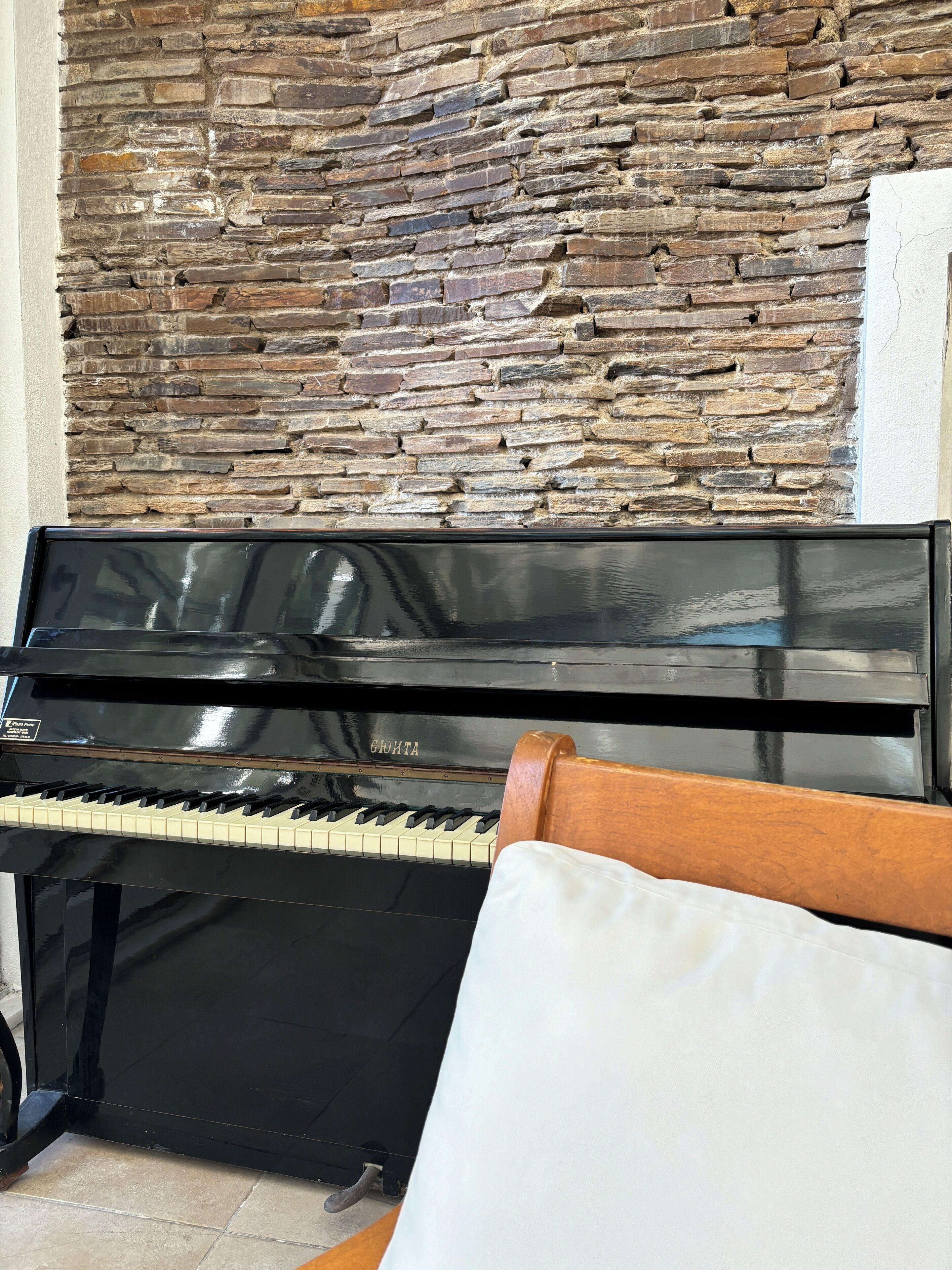 Um piano com um fundo de parede de pedra.