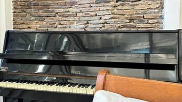 Um piano com um fundo de parede de pedra.
