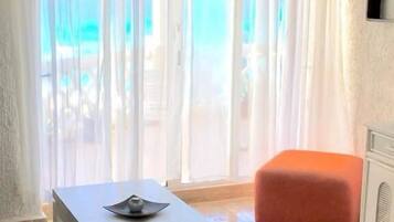 Apartamento família, várias camas, vista para a praia | Área de estar | TV de tela plana