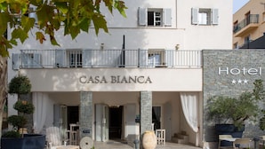 Um hotel chamado "Casa Bianca" com fachada de pedra, área de estar ao ar livre e varanda com guarda-corpos.