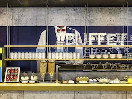 Balcão de buffet com um grande letreiro, várias estações de serviço e uma variedade de opções de comida e bebida.